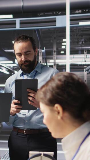 Vertical Data Scientists Working Together In Server Room Reviewing