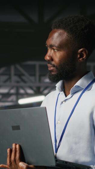 Vertical Engineers in data center using laptop to monitor neural network LLM visualization ...