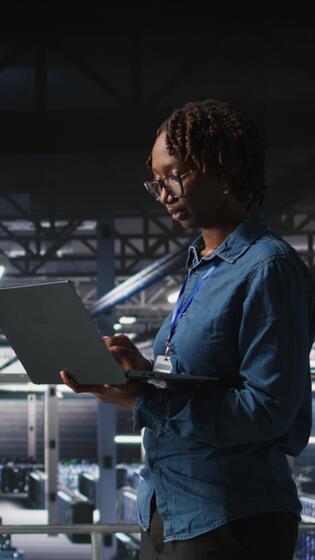 Vertical Portrait Of Joyful Computer Scientist In Data Center