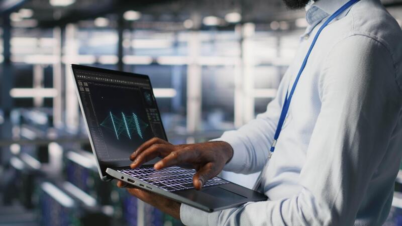 Engineer And Colleague In Data Center Reviewing Large Language Model Visualizations On Laptop