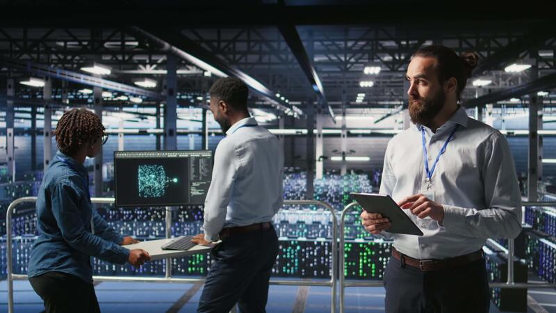 Technicians On Data Center Platform Using Devices To Monitor Neural