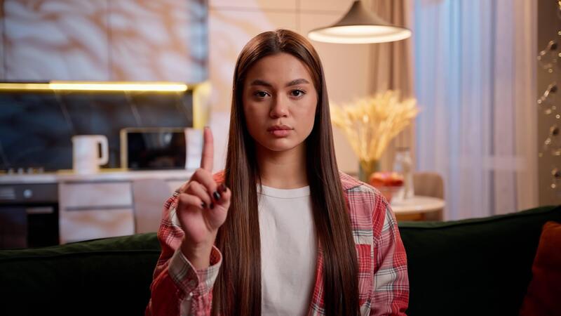 Serious woman girl teen shaking finger no hand gesture negative refusal rejection disapproval ...