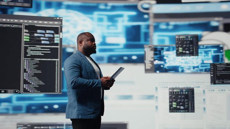 African American developer working on programming and automation, coding on a laptop with a ...