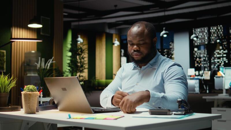 Black guy documenting essential ideas on paper and reading on laptop ...