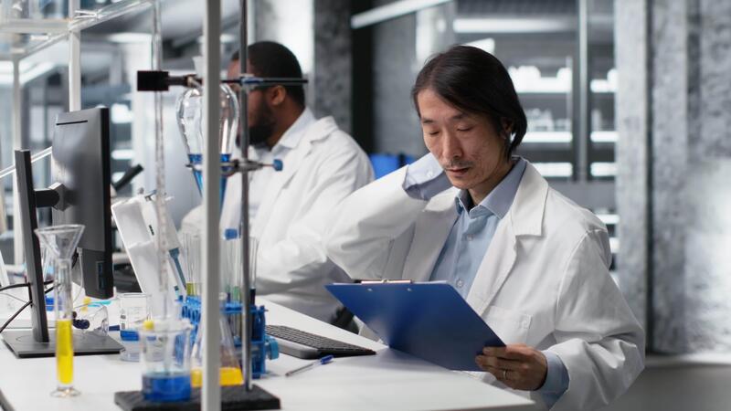 Senior laboratory scientist feeling neck ache while using computer to log patient data clinical ...