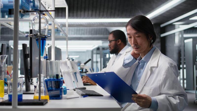 Senior laboratory scientist feeling neck ache while using computer to log patient data clinical ...