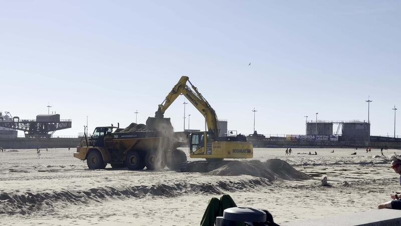 Matosinhos, Portugal May 20 2025 excavator and dump truck work on the sandy beach. The ...